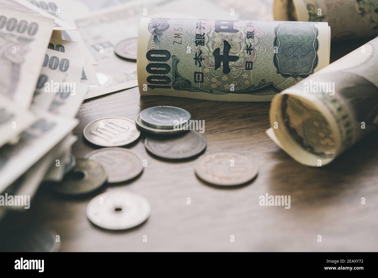 Closeup of Japanese yen money bills and coins on wood table background ...
