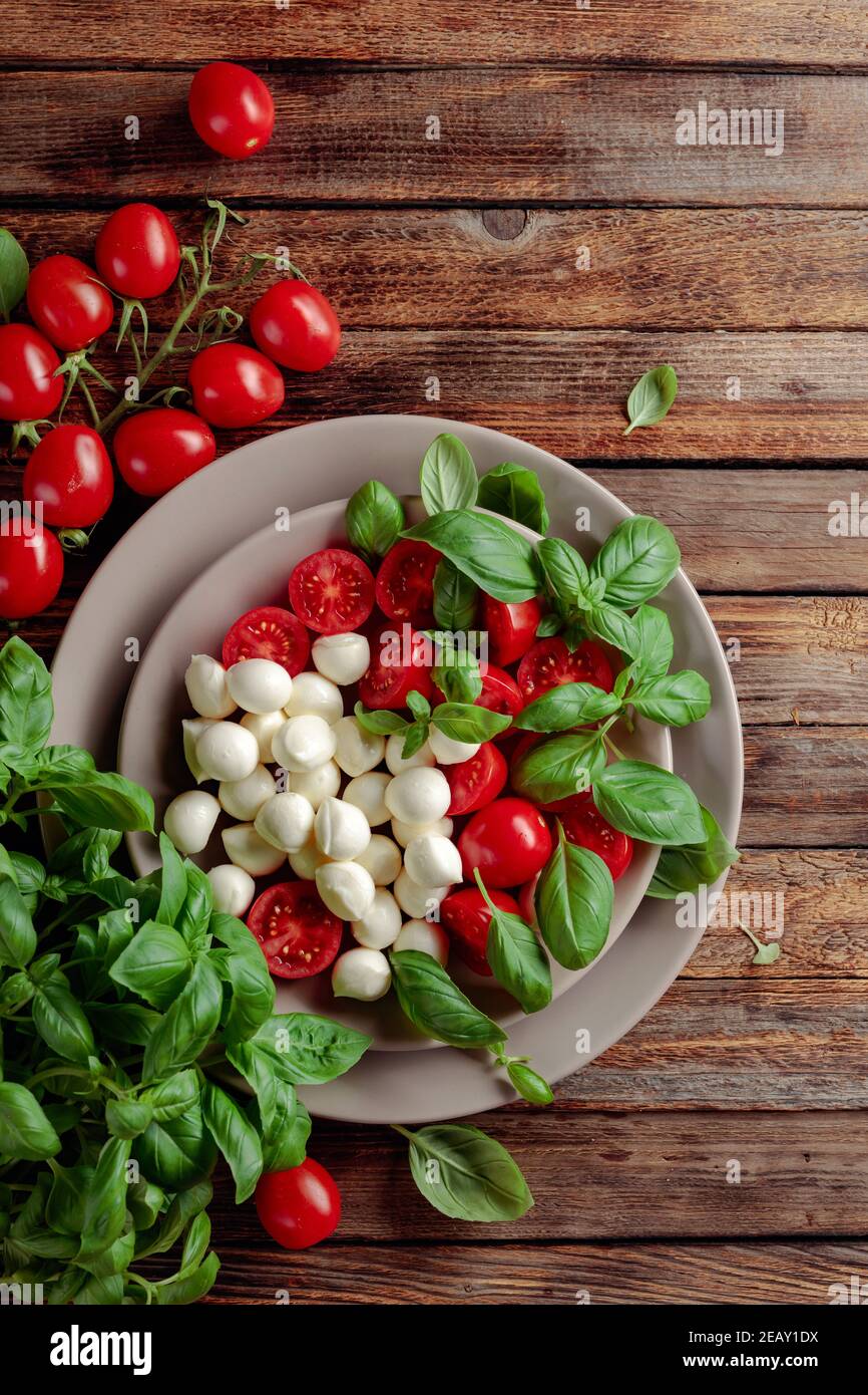 Caprese Salad With Tomato Mini Mozzarella And Basil On A Old Wooden