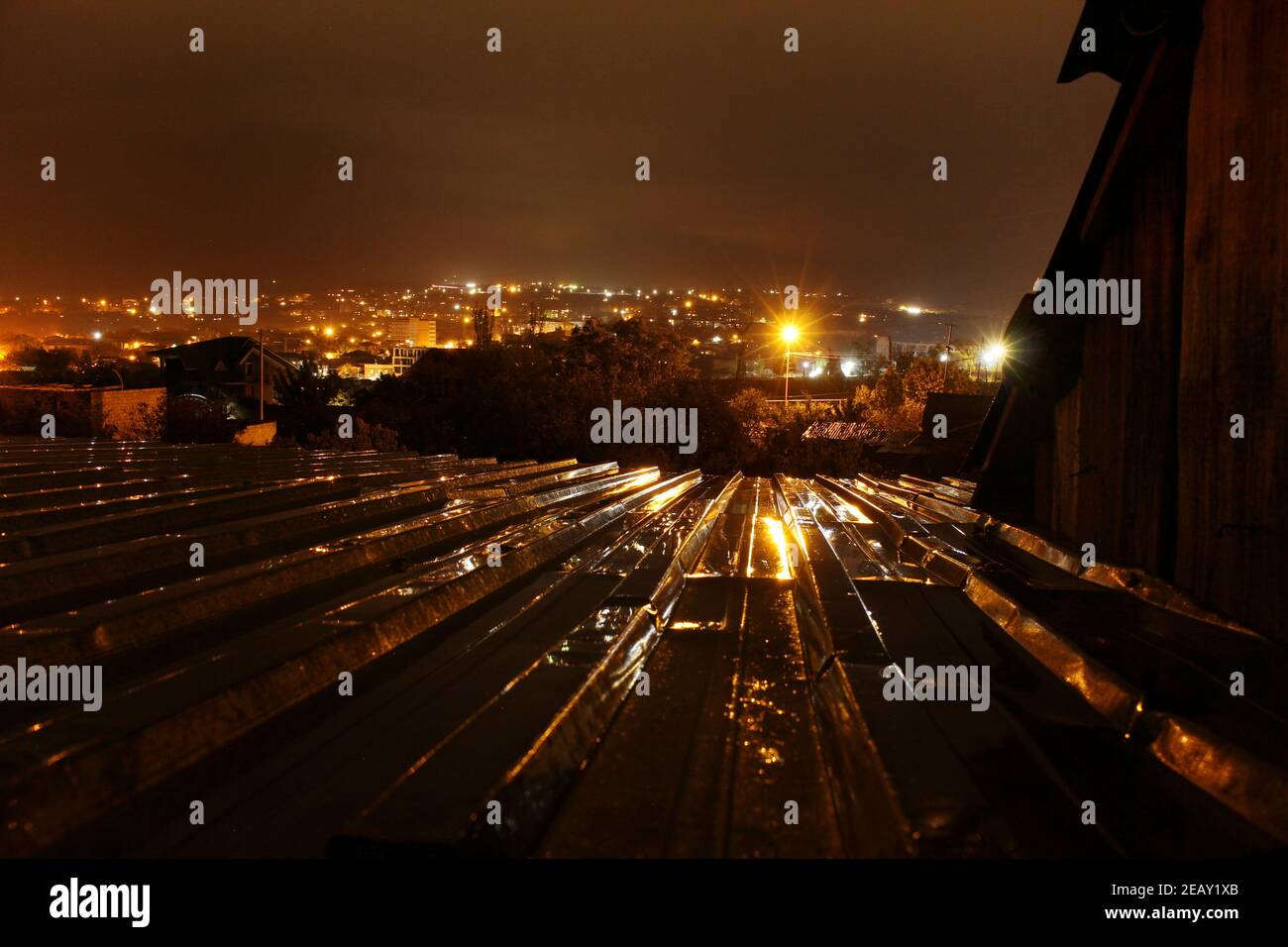 Long exposure photography. A night view of the town from the wet roof ...