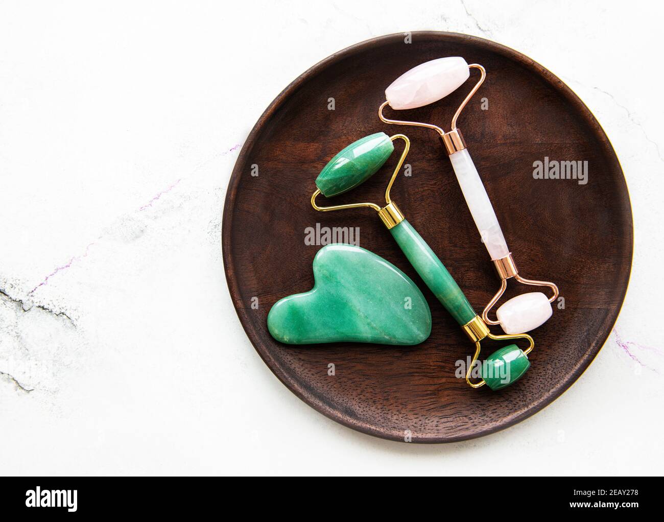 Jade face rollers for beauty facial massage therapy. Flat lay on white ...