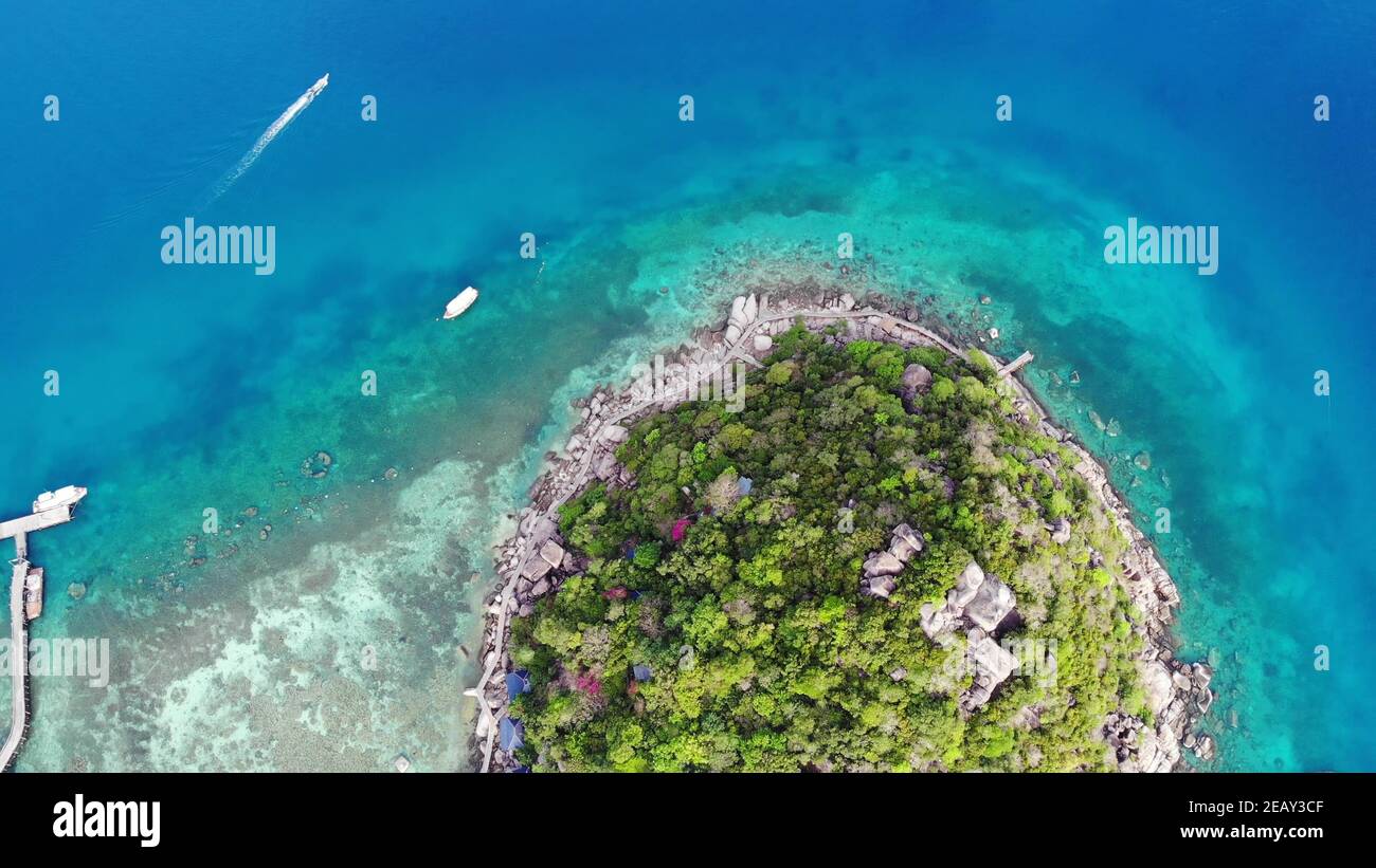 Calm colorful azure turquoise sea near tiny tropical volcanic island ...