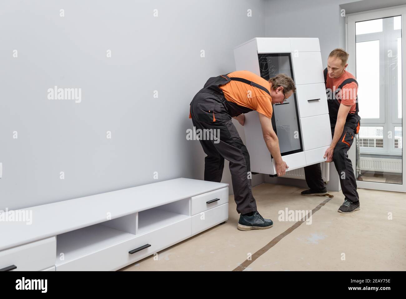 Workers move and install furniture in the apartment Stock Photo - Alamy