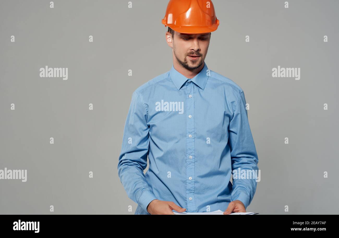 male architect in orange hard hat working gray background cropped view ...
