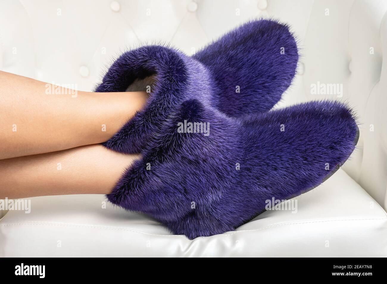 Beautiful fluffy fur footwear on women legs Stock Photo - Alamy
