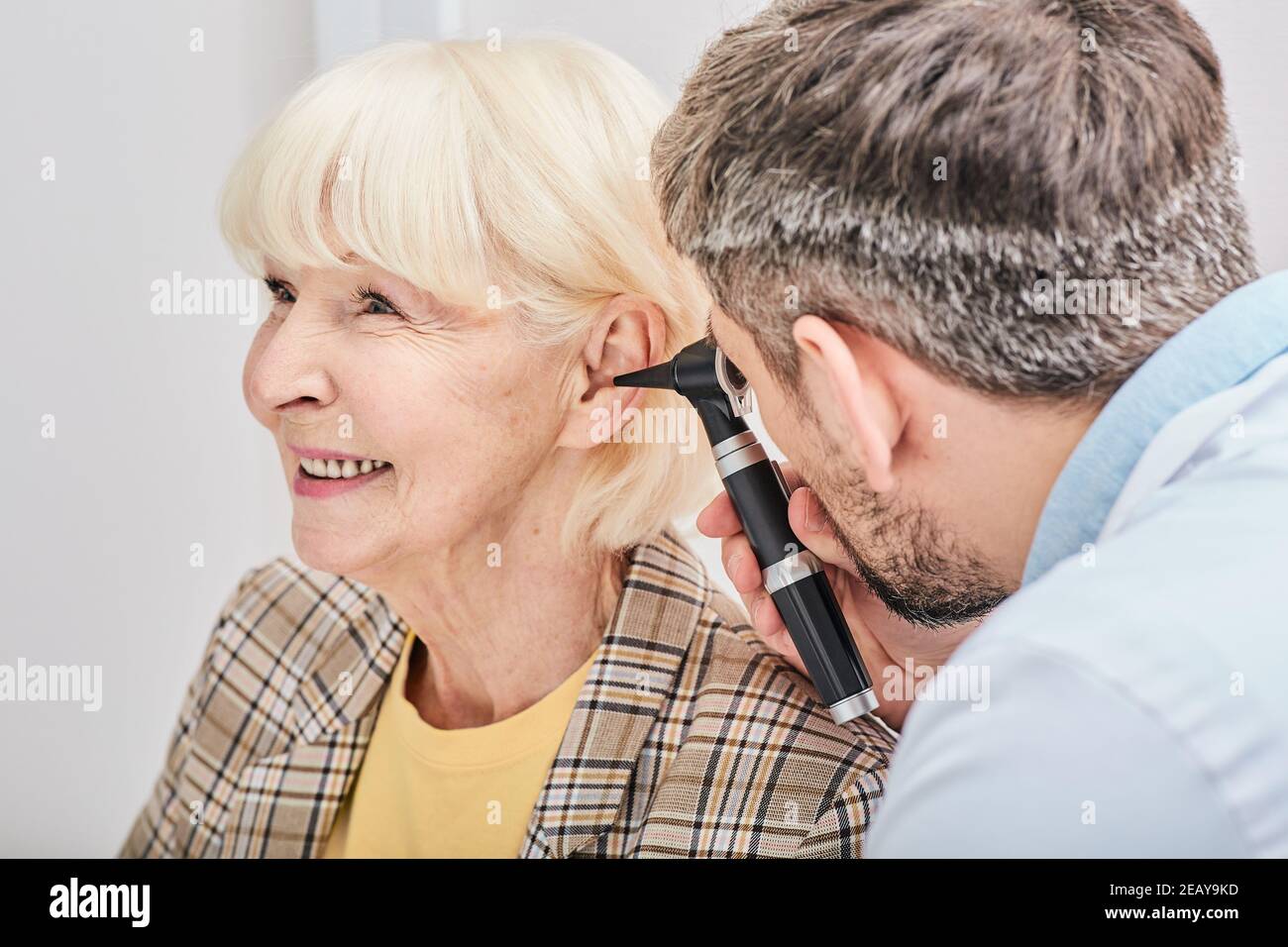 Elderly woman during ear exam at a hearing clinic. Audiologist ...