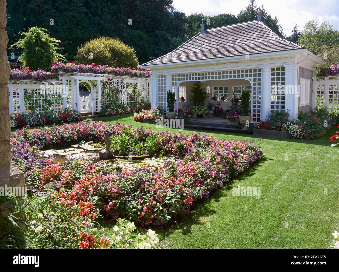 Butchart Gardens, the former Butchart residence. Petunias top the arbor ...