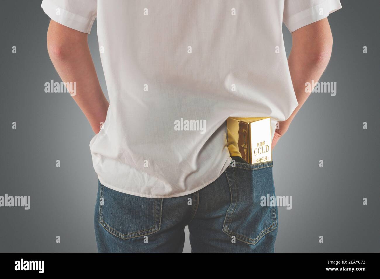 The rear view of a young man with a bar of gold in his back pocket ...