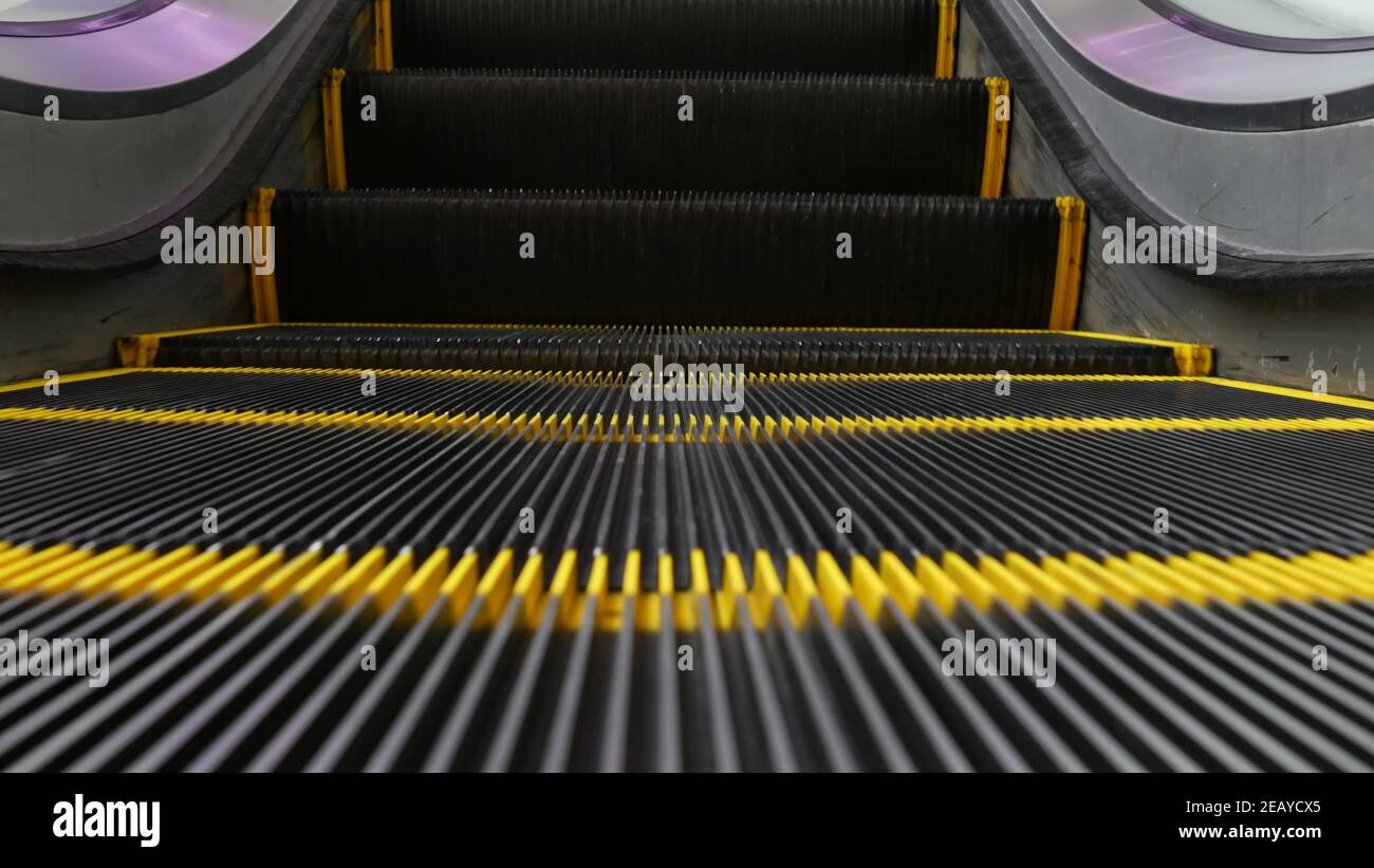 Low angle looped perspective view of modern escalator stairs. Automated ...