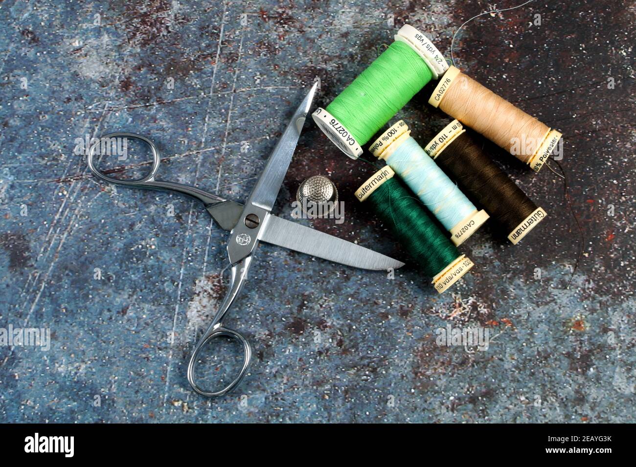 High angle shot of colorful threads, scissors, and sewing tools on a ...