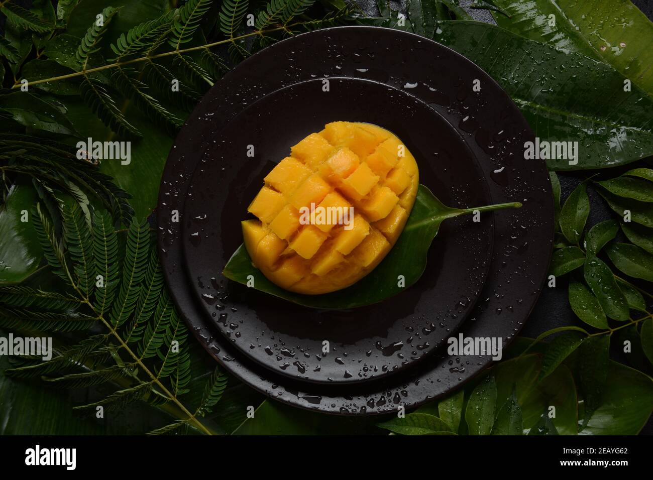 Fresh mango fruit with sliced diced mango chunks on a plate or on ...