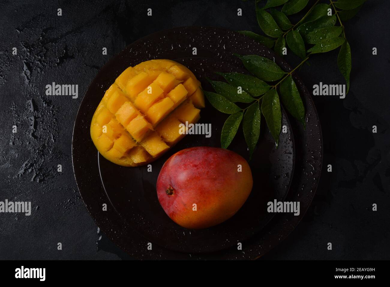 Fresh mango fruit with sliced diced mango chunks on a plate or on ...