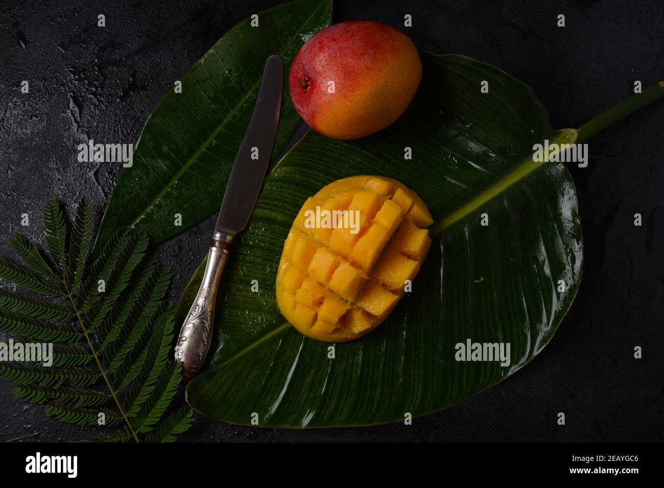 Fresh mango fruit with sliced diced mango chunks on a plate or on ...