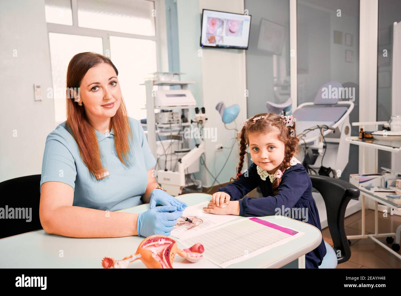 Girl studying female reproductive system with doctor in gynecological ...