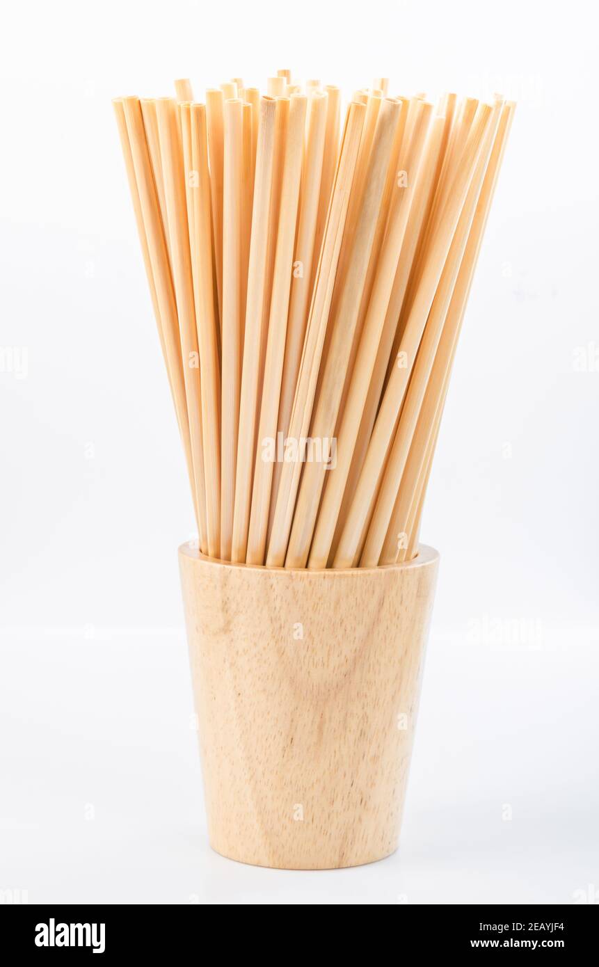 Wheat straw for drinking water in wooden glass on white background ...