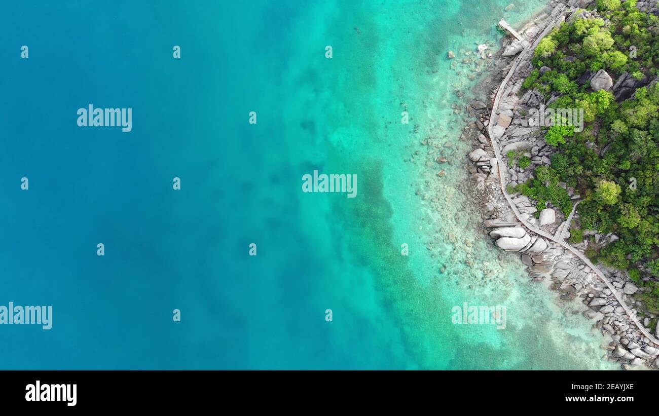 Calm colorful azure turquoise sea near tiny tropical volcanic island ...