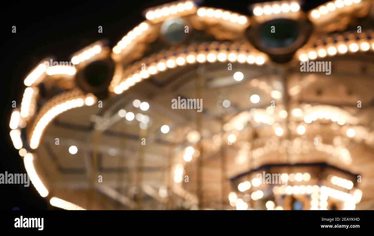 Illuminated blurred merry go round in park. Brightly illuminated ...