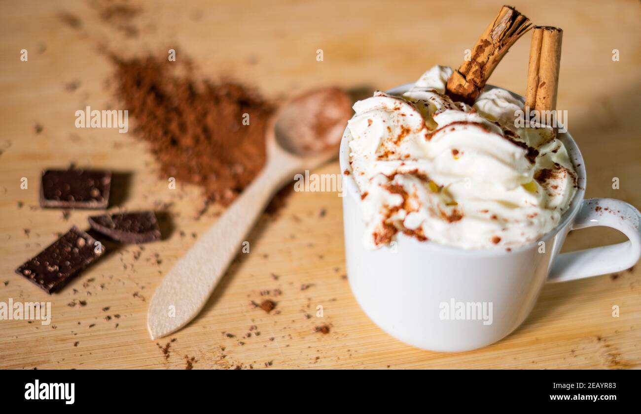 Closeup shot of a cup of coffee with whipped cream cocoa powder and ...
