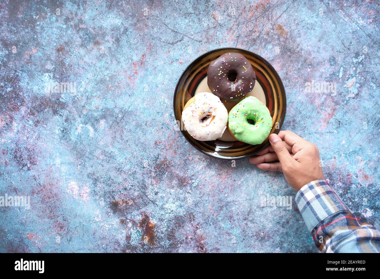 top view of hand holding donuts Stock Photo - Alamy