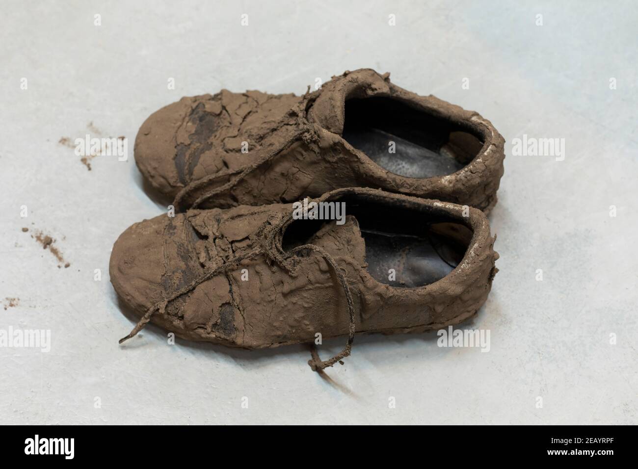 Dirty dried muddy and messy sneaker shoes totally covered with mud ...