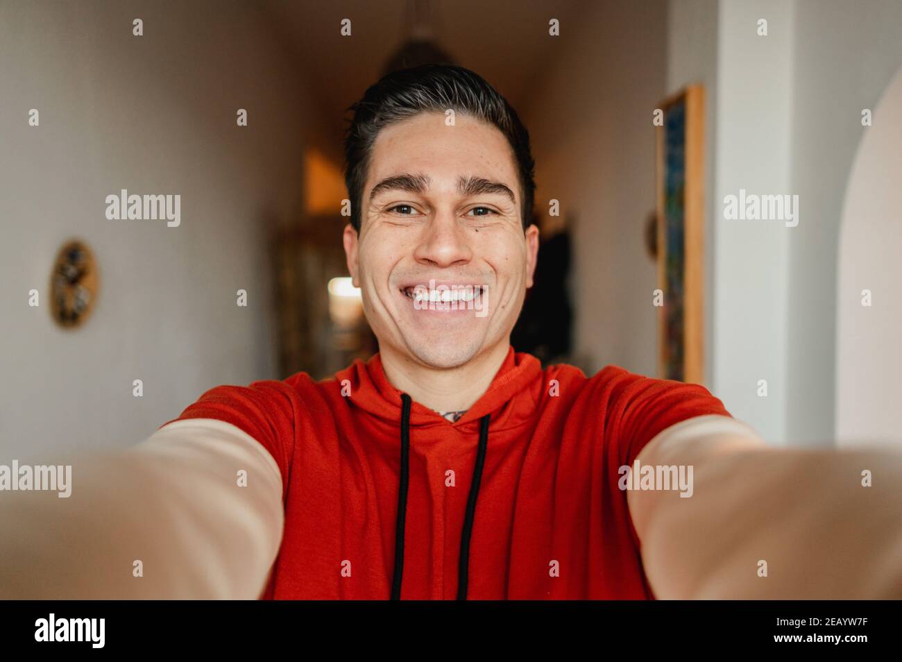 Young casual man smiling while taking a selfie portrait looking at the ...