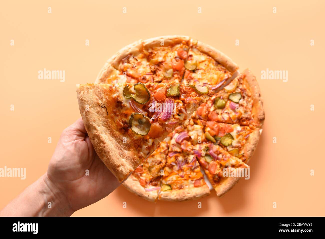 Womans hand take a fresh Italian pizza with vegetables. Delivery food ...