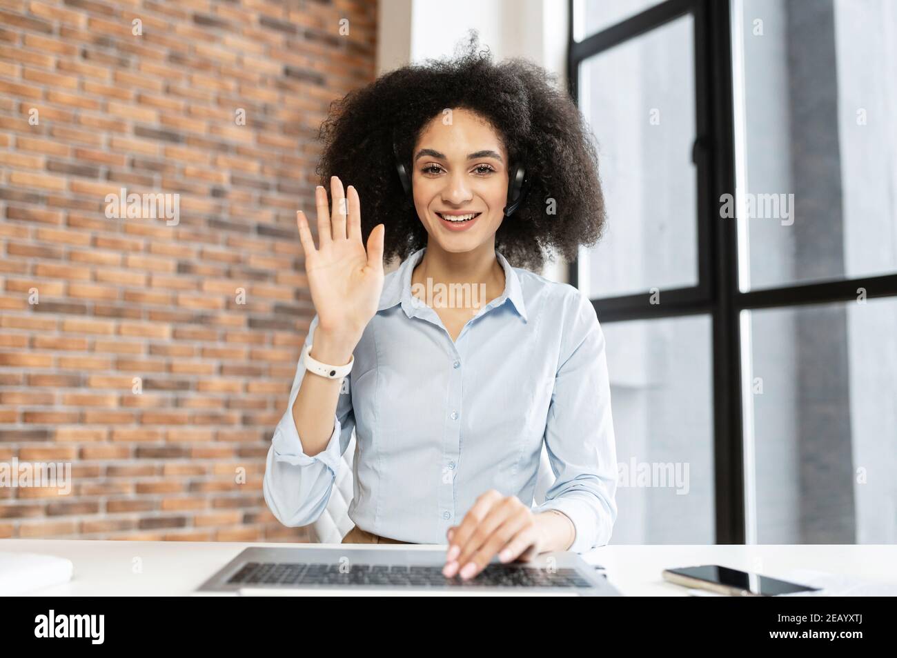 Front view of a young mixed-race female customer service agent in a ...