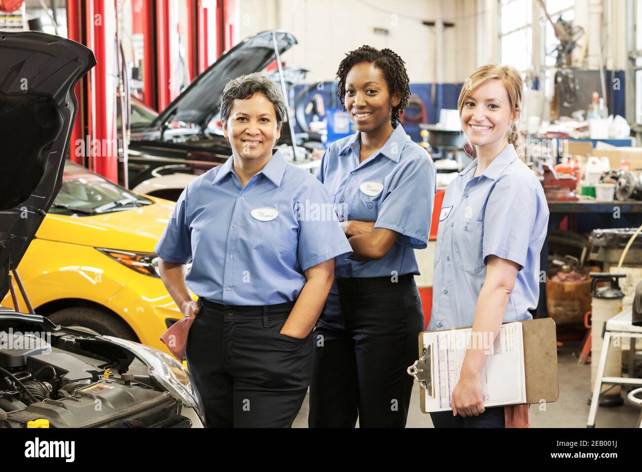 Portrait of three smiling female mechanics in auto repair shop Stock ...