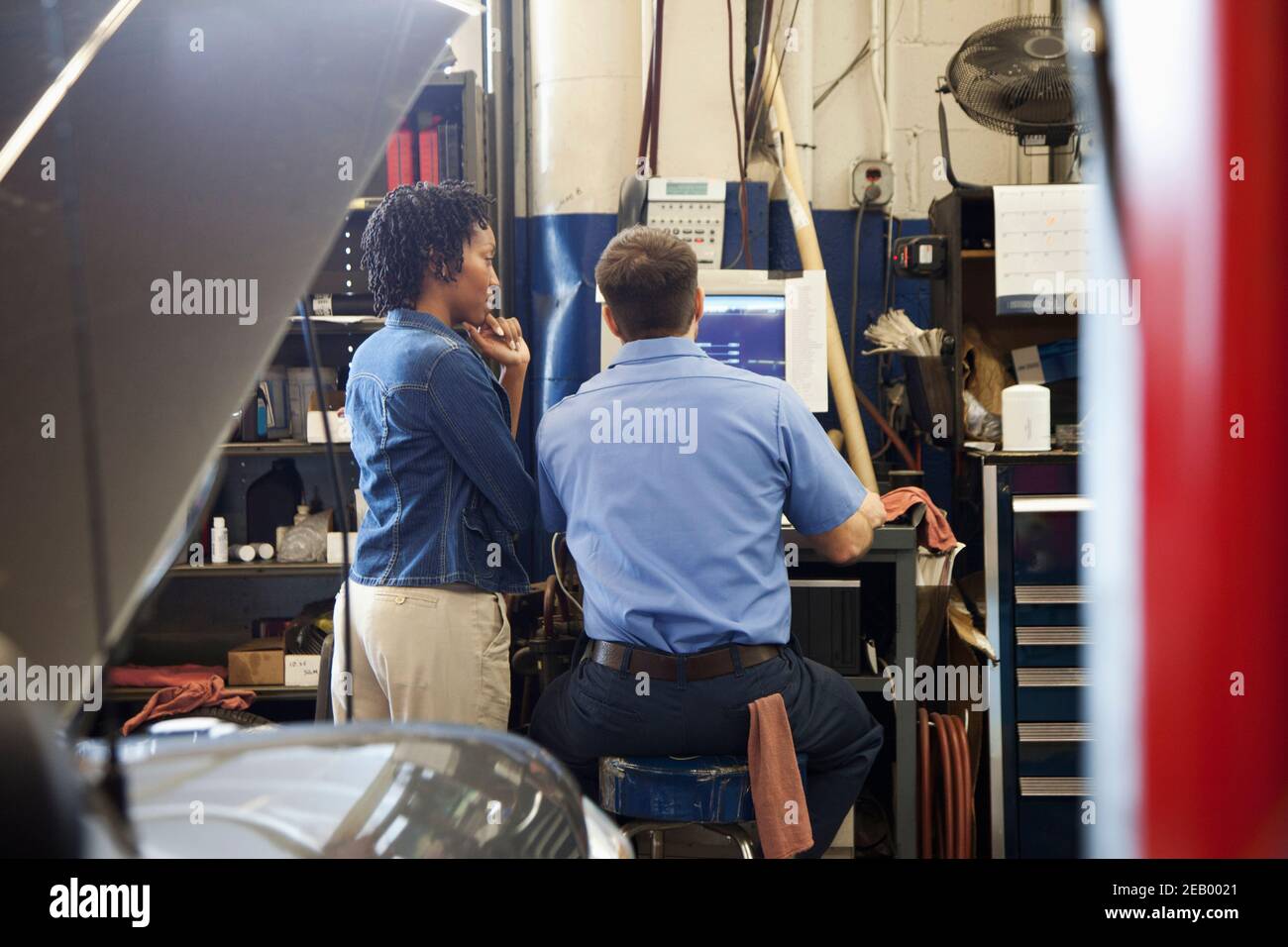 Mechanic and customer look at computer screen in auto repair shop Stock ...