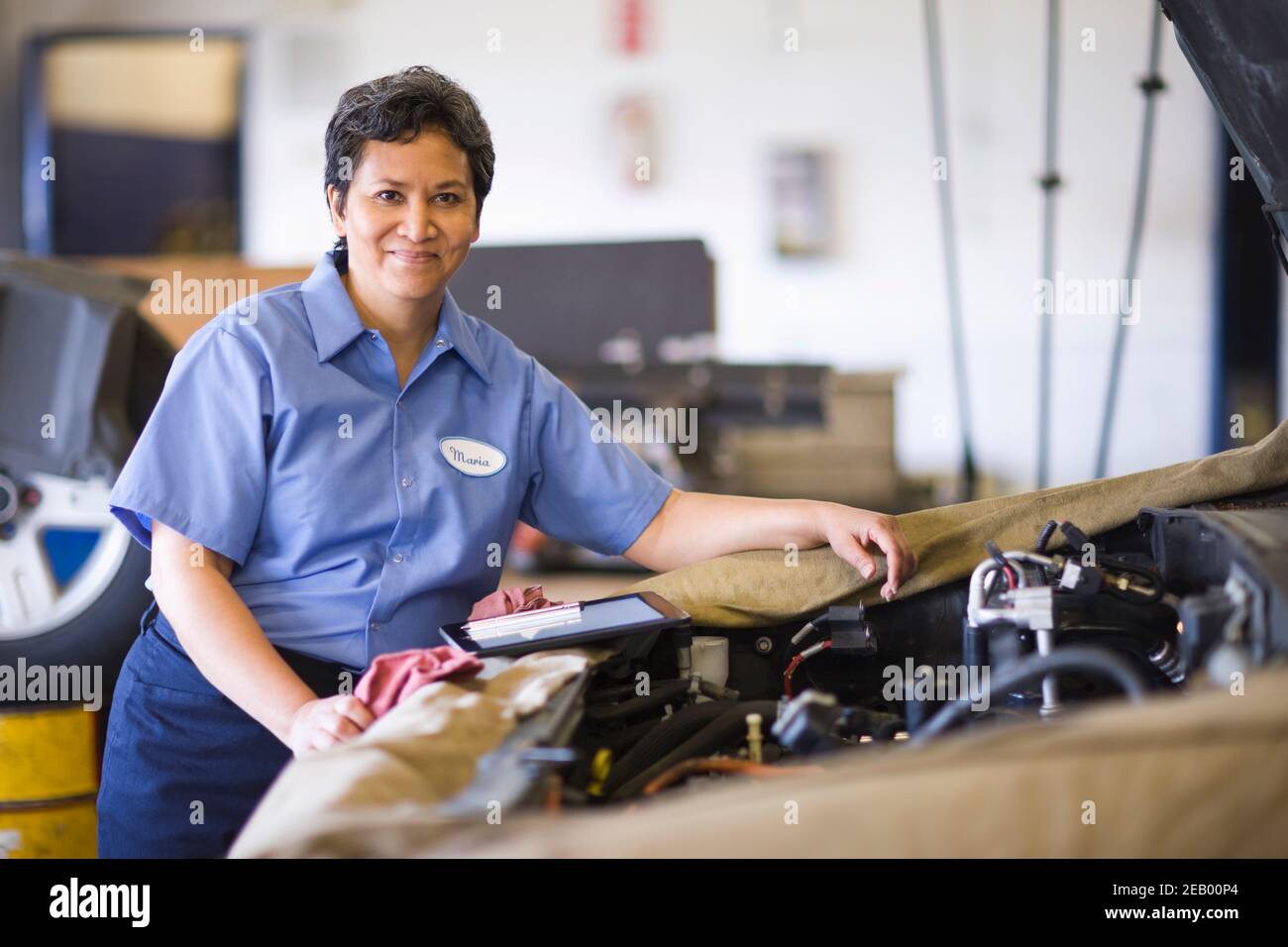 Portrait of female hispanic mechanic in auto repair shop Stock Photo ...