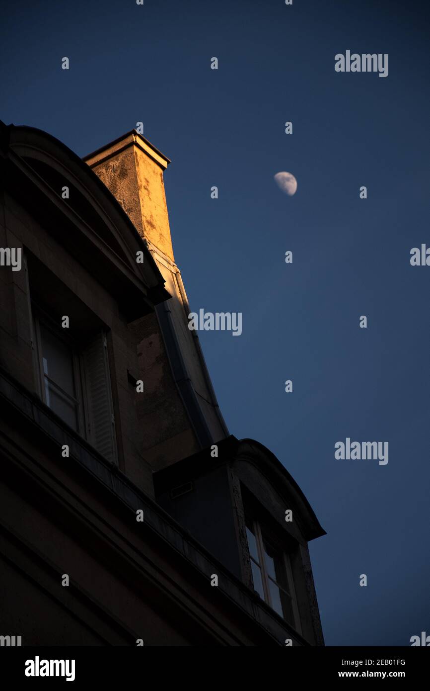 Moon over chimney. Parisian typical house with mansard. Chimney in ...