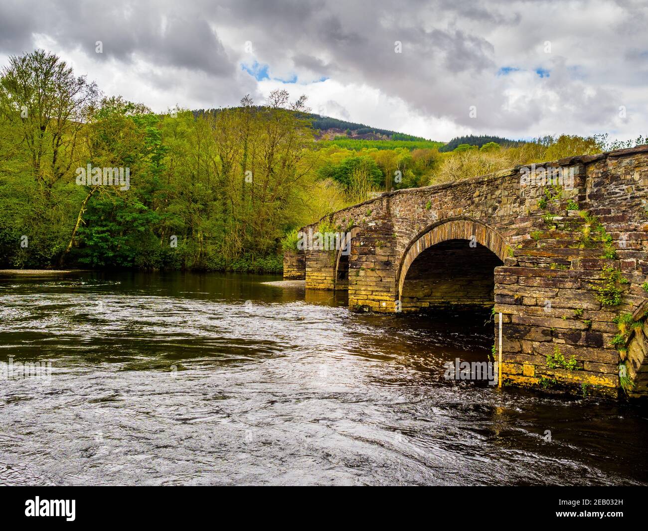A bridge over a river tributary near Cymer Abbey ruins in Snowdonia ...