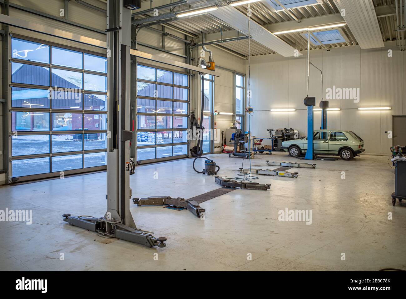 in a big empty car workshop there are some car lifts Stock Photo - Alamy