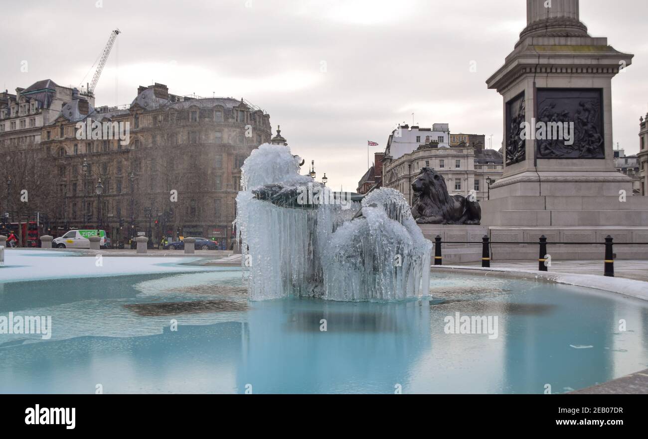 A fountain is completely covered in ice in Trafalgar Square, London ...