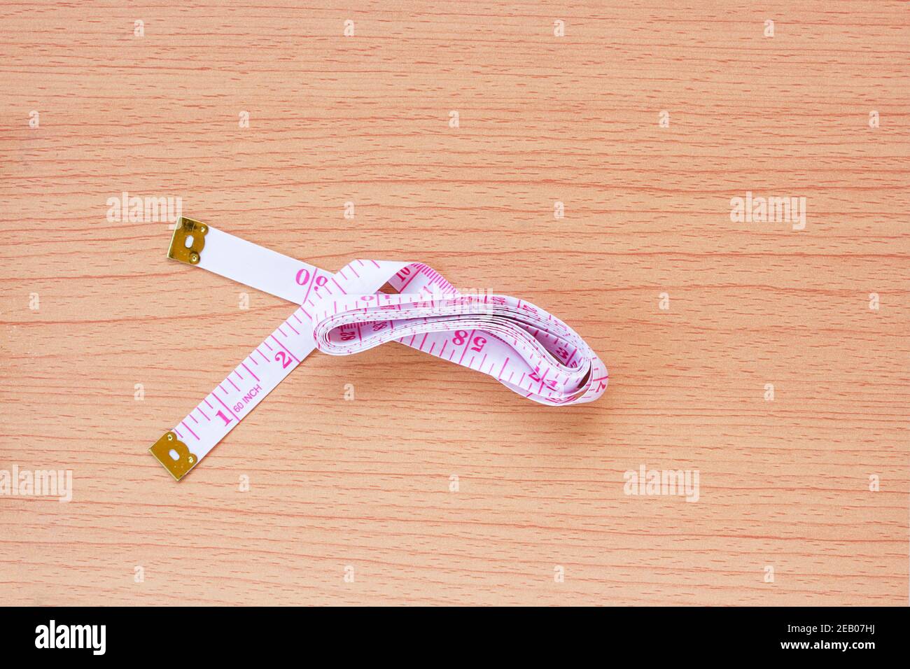 Measuring tape on a wooden table. top view for design Stock Photo - Alamy