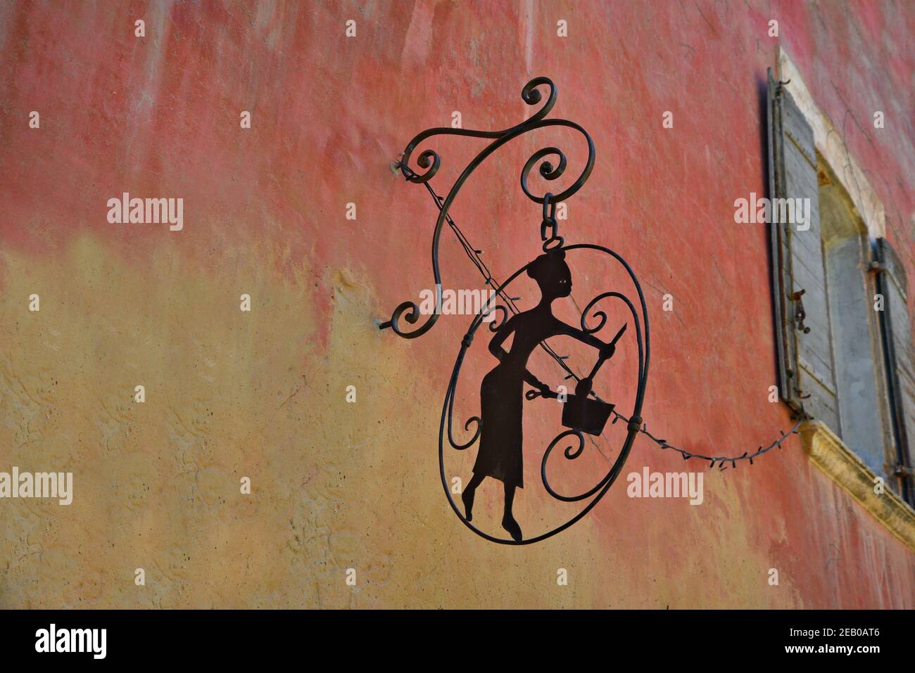Rural bakery iron sign on a faded stucco wall in the medieval village ...