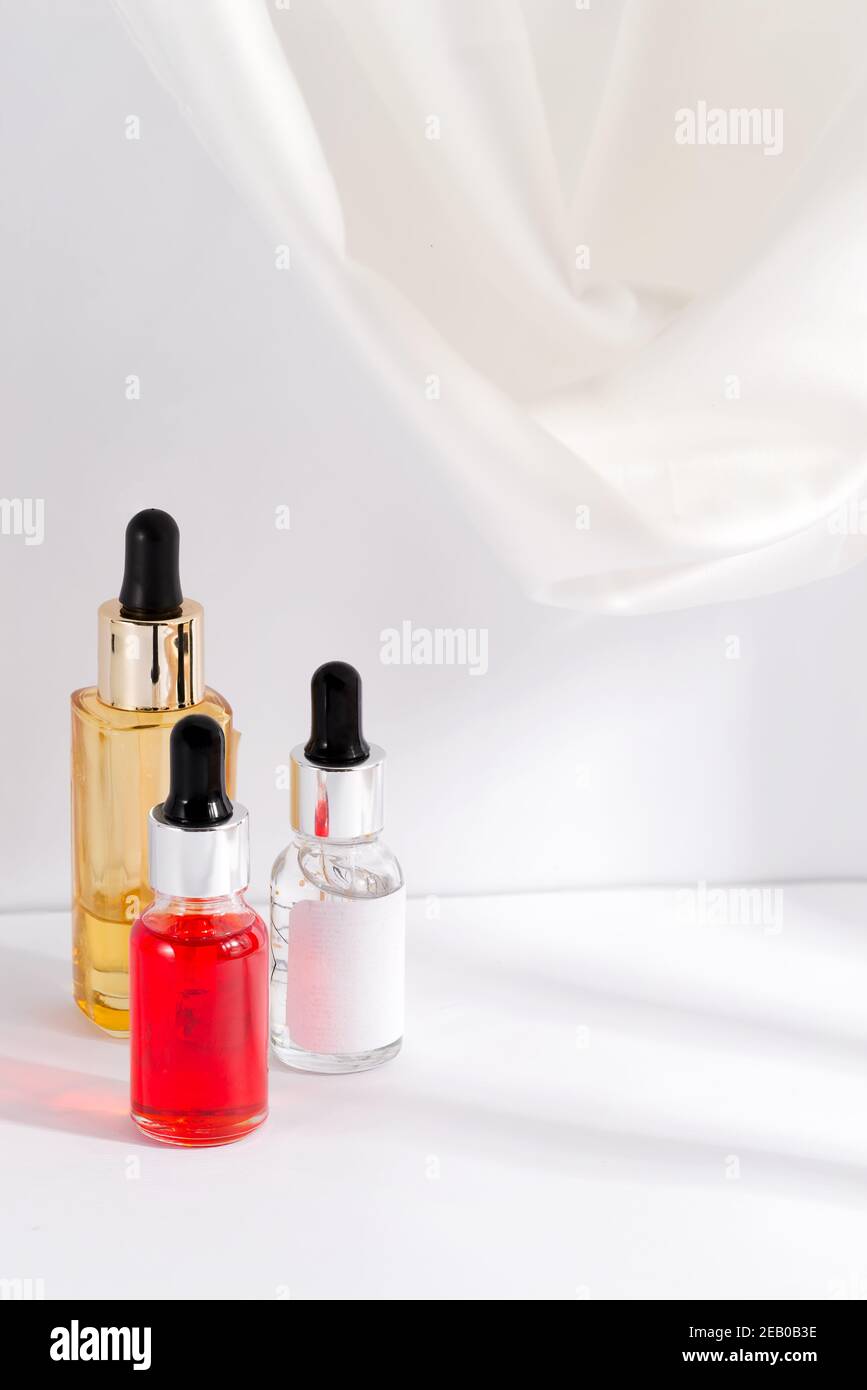 Colorful serum essence in glass bottle on white stand background with ...