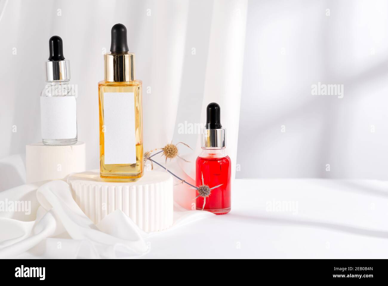 Colorful serum essence in glass bottle on white stand background with ...