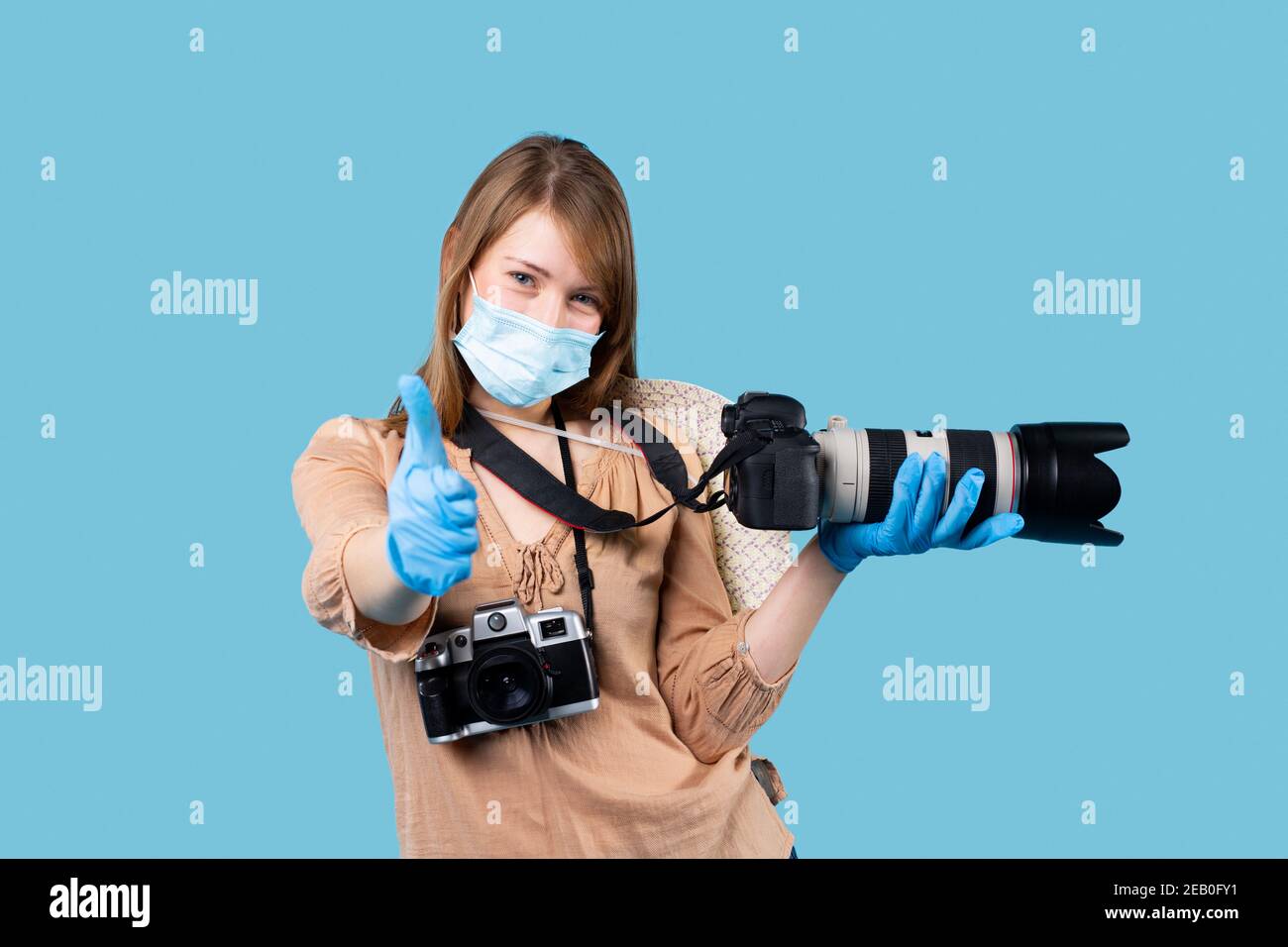 Young girl photographer with photo-video cameras on with protective ...