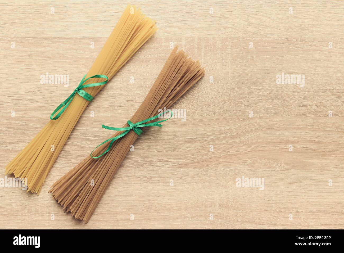 Two bundles of dry spaghetti pasta on a light background with copy ...