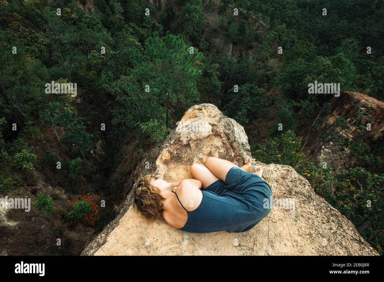 Young girl lying on top of the rock in the canyon Stock Photo - Alamy