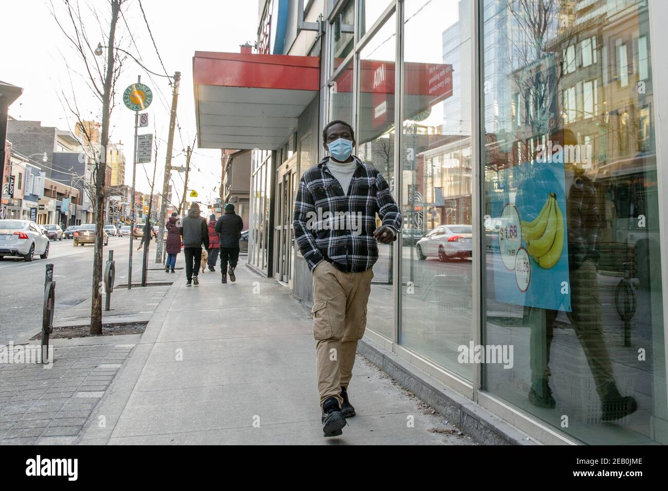 People wear face masks, walk along Queen street during COVID-19 ...