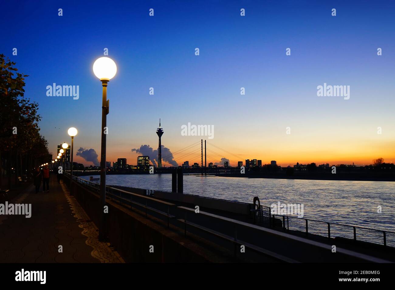 Nicely illuminated promenade at Rhine river in Düsseldorf with the two ...