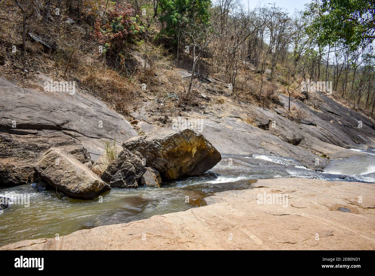 awesome view of waterfall passing through a mountain big rock near by ...