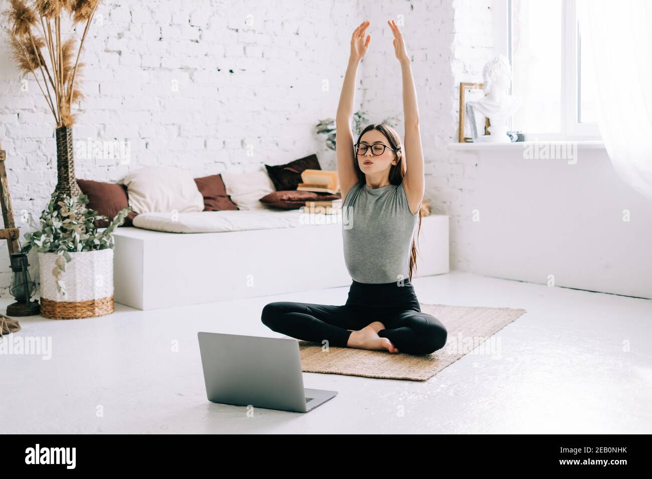 Beautiful brunette fitness woman make stretching exercises in front ...
