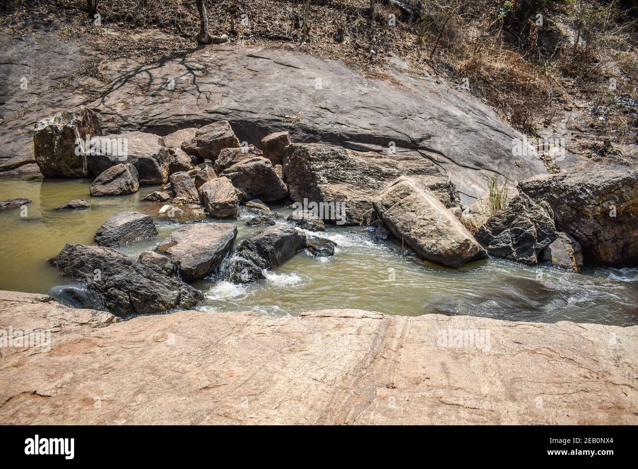 awesome view of waterfall passing through a mountain big rock near by ...