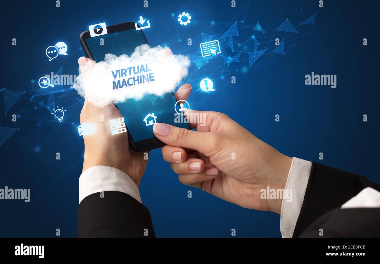 Female hand holding smartphone with VIRTUAL MACHINE inscription, cloud ...