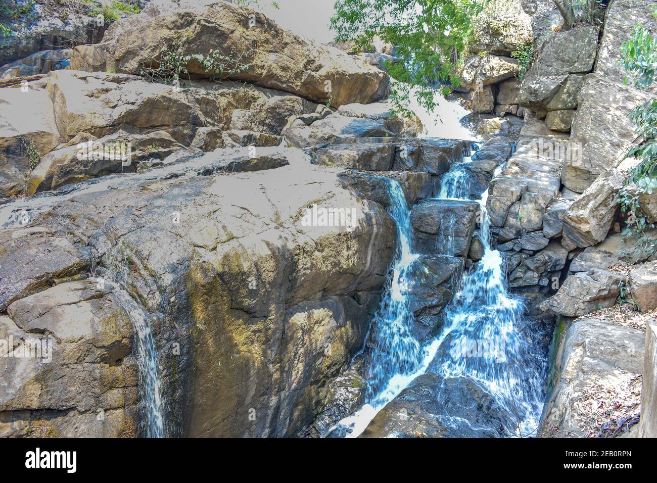 awesome view of waterfall passing through a mountain big rock near by ...