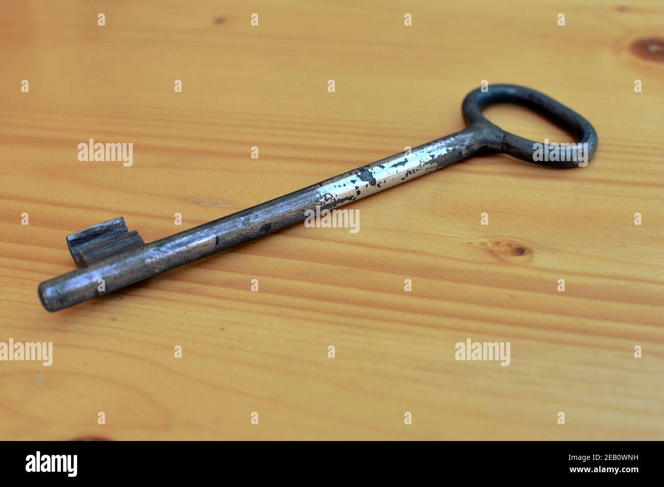 Old big key on natural wood background Stock Photo - Alamy
