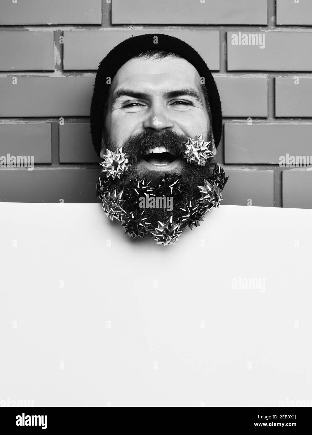 paper sheet on brown brick wall studio background. Bearded man, long ...