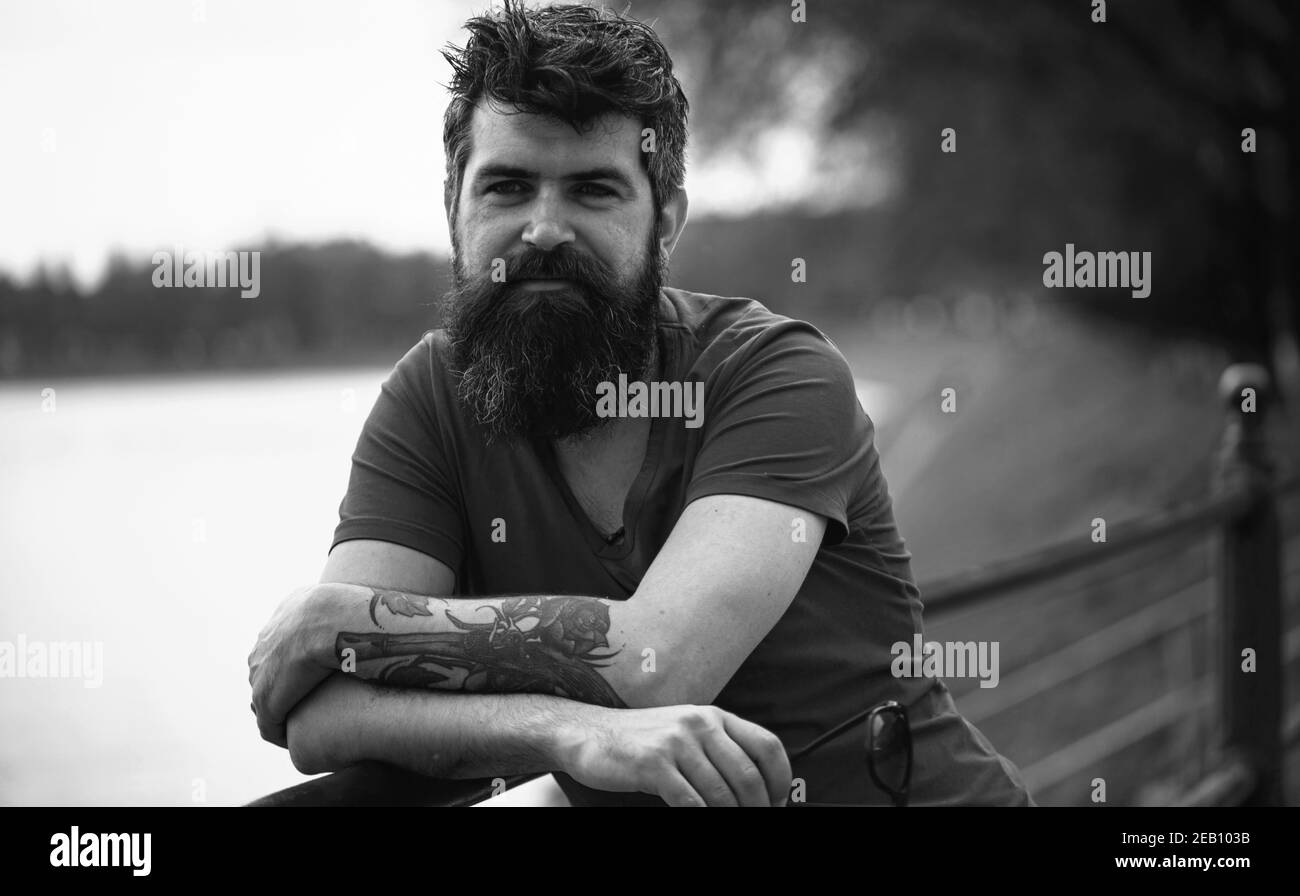 Hipster on thoughtful face standing at riverside, thinking, dreaming ...